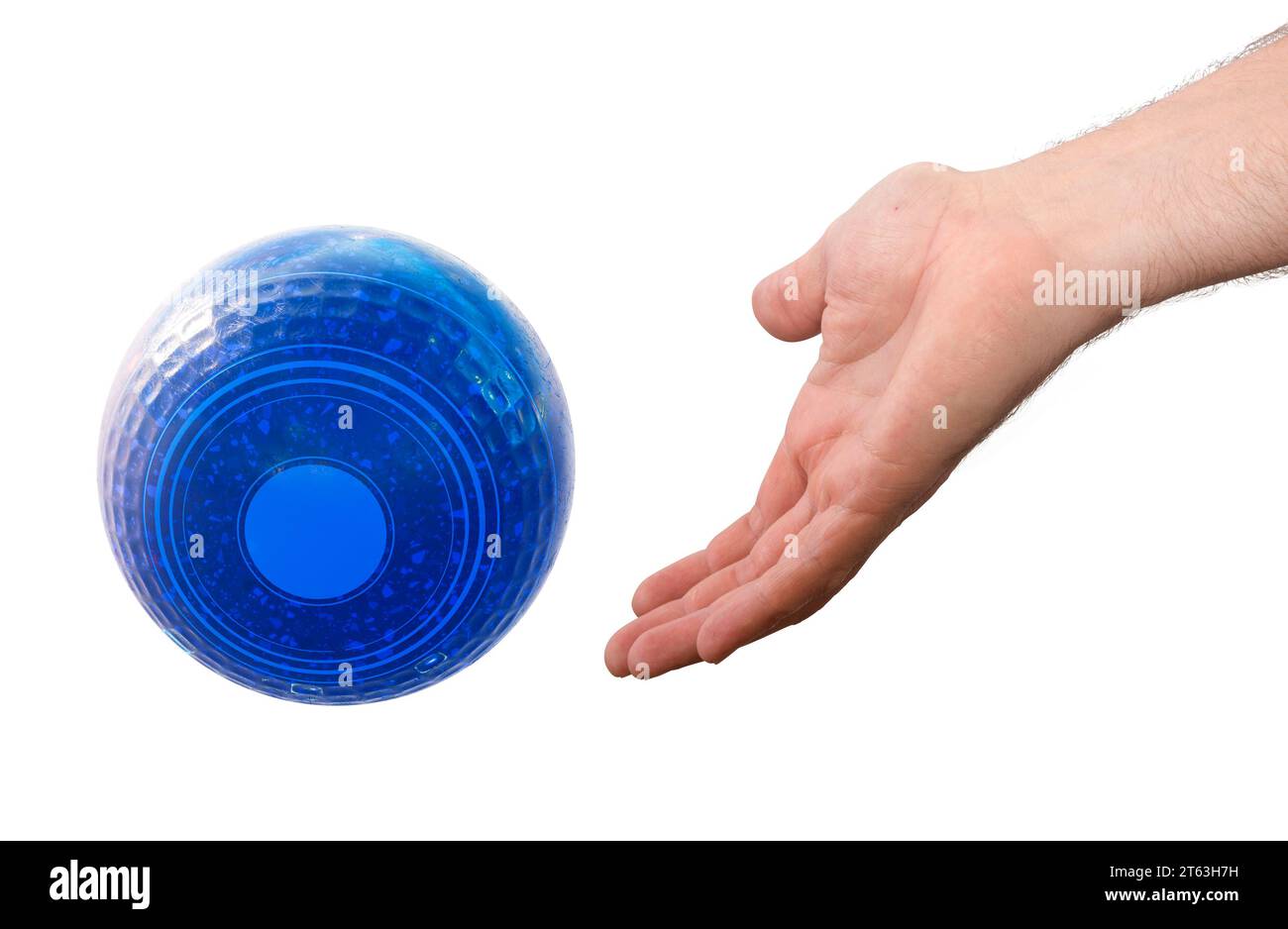 A male hand bowling and releasing a blue wooden lawn bowling ball on an ...