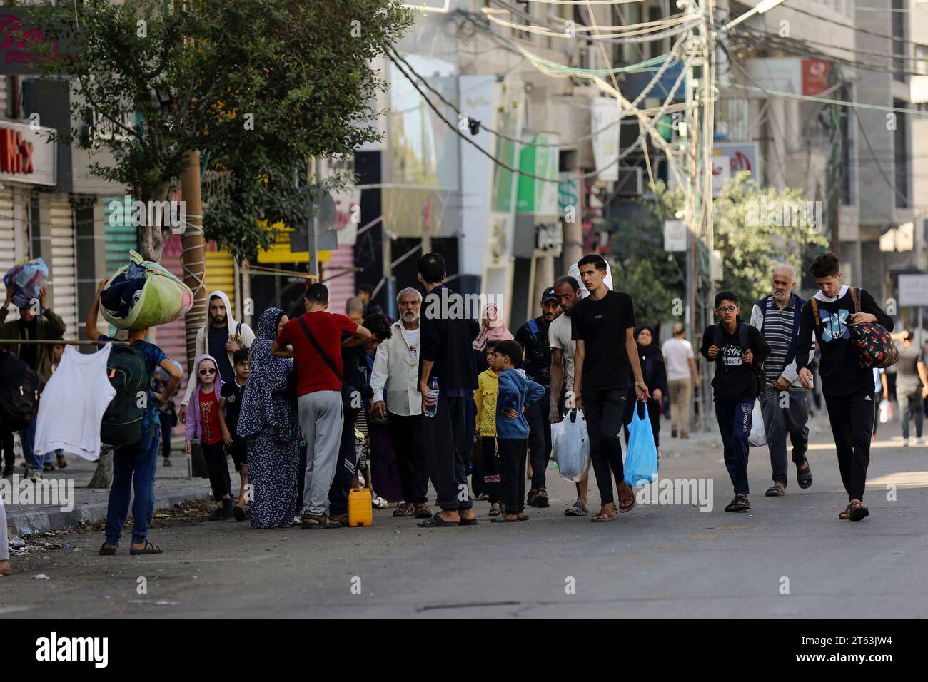Palestinians walk in the al-Rimal neighbourhood, central Gaza City ...