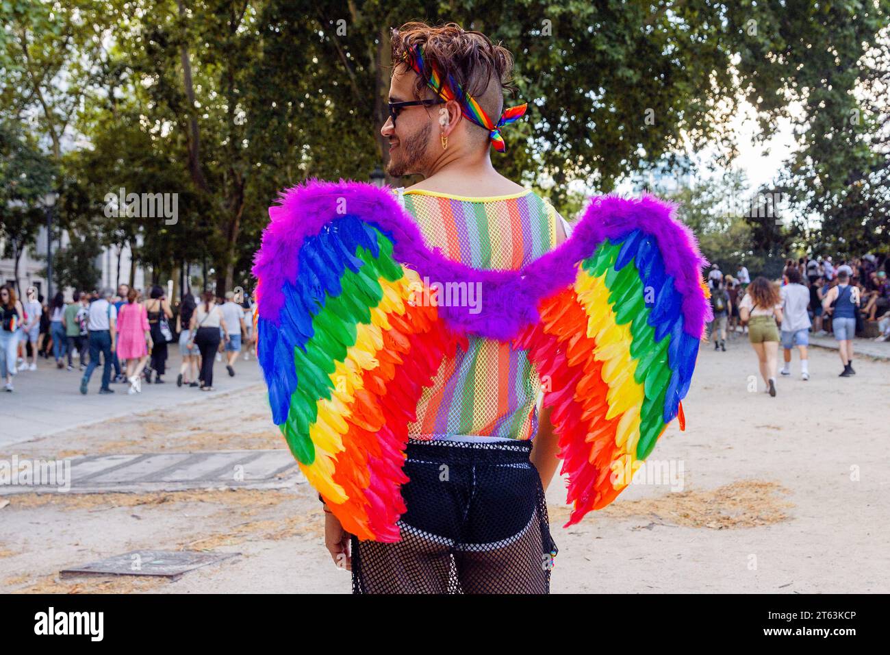 Back view of man donning vibrant rainbow colored wings and matching ...