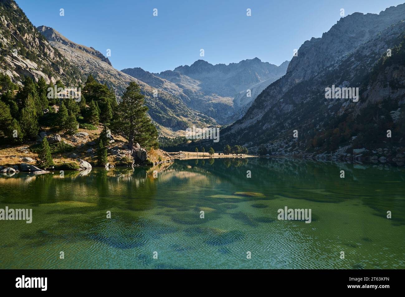 Crystal clear waters of an alpine lake nestled between majestic ...