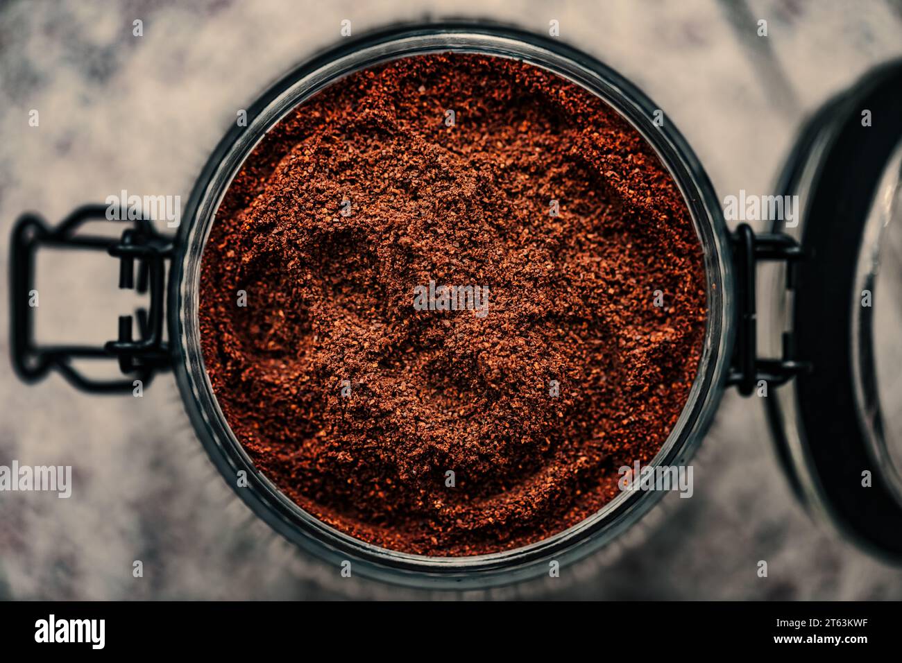 Top view of finely ground coffee filling a ribbed glass jar ...
