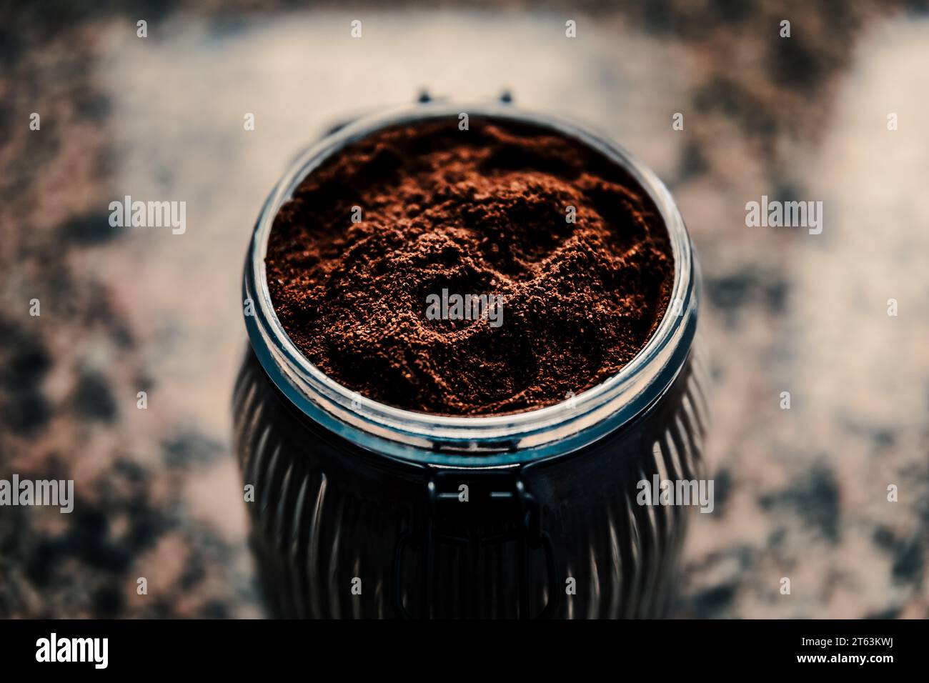 Top view of finely ground coffee filling a ribbed glass jar ...