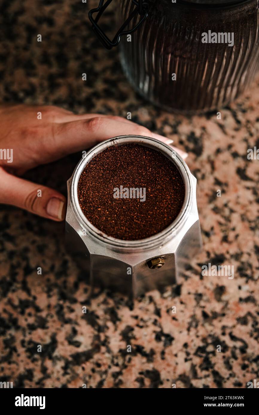 Top view of freshly ground coffee filled to the brim of stainless steel ...