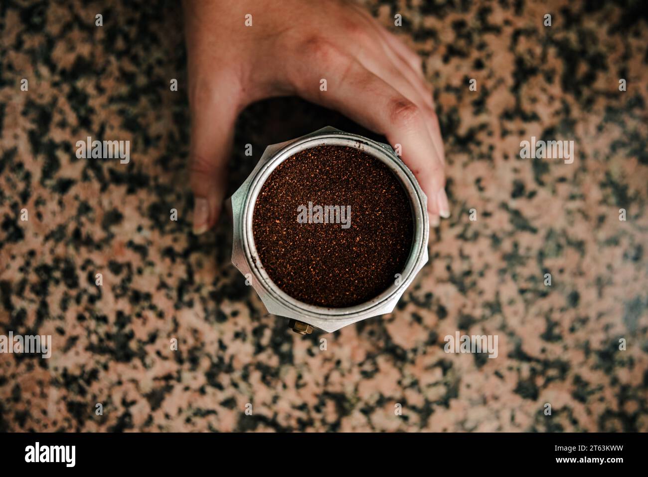 Top view of freshly ground coffee filled to the brim of stainless steel ...