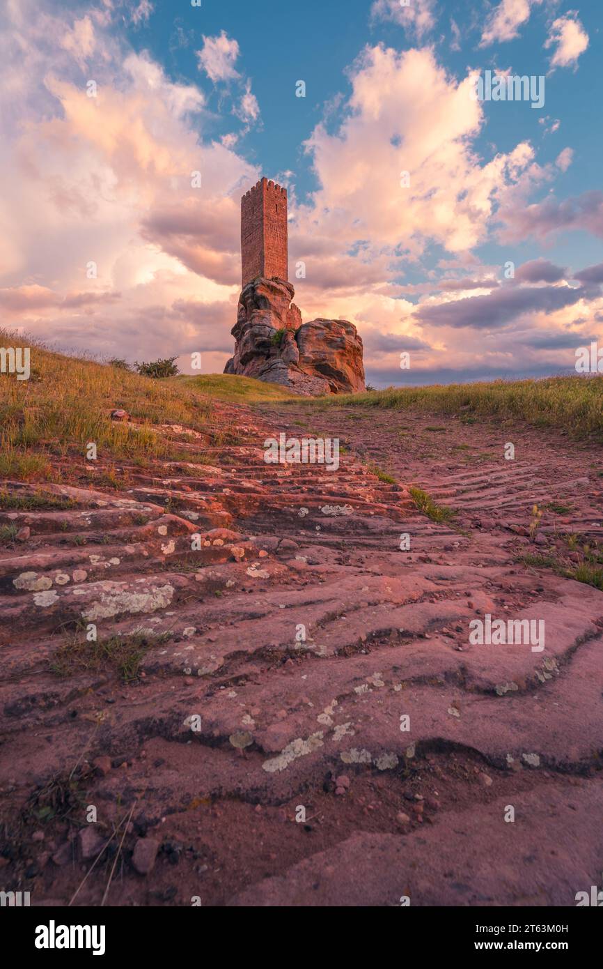 From below of ancient tower perched atop a rugged boulder against a ...