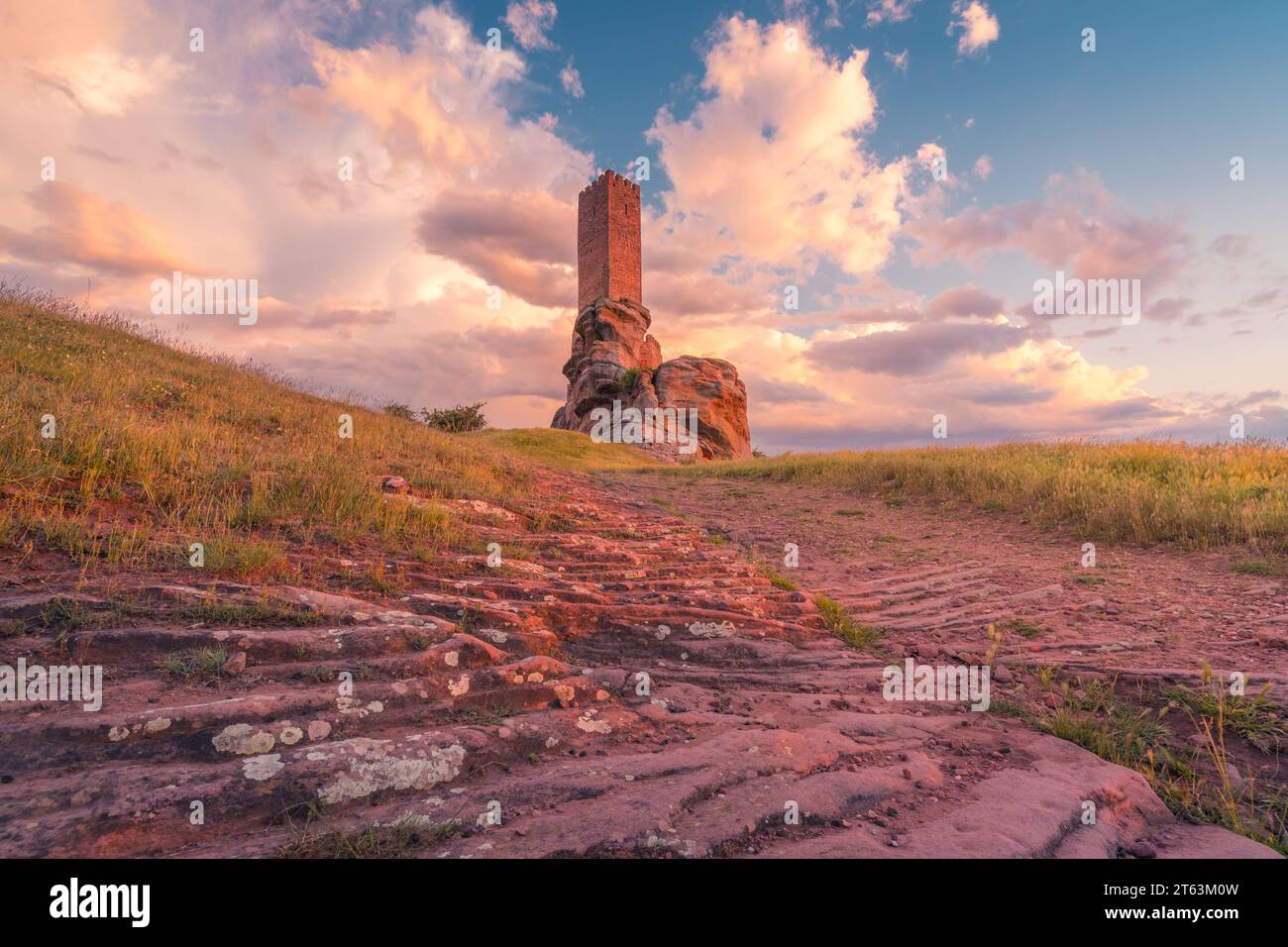 From below of ancient tower perched atop a rugged boulder against a ...