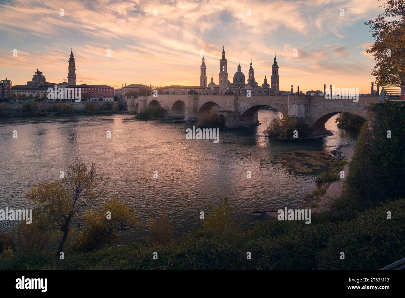 Arched stone bridge and Basilica of Nuestra Senora del Pilar over Ebro ...
