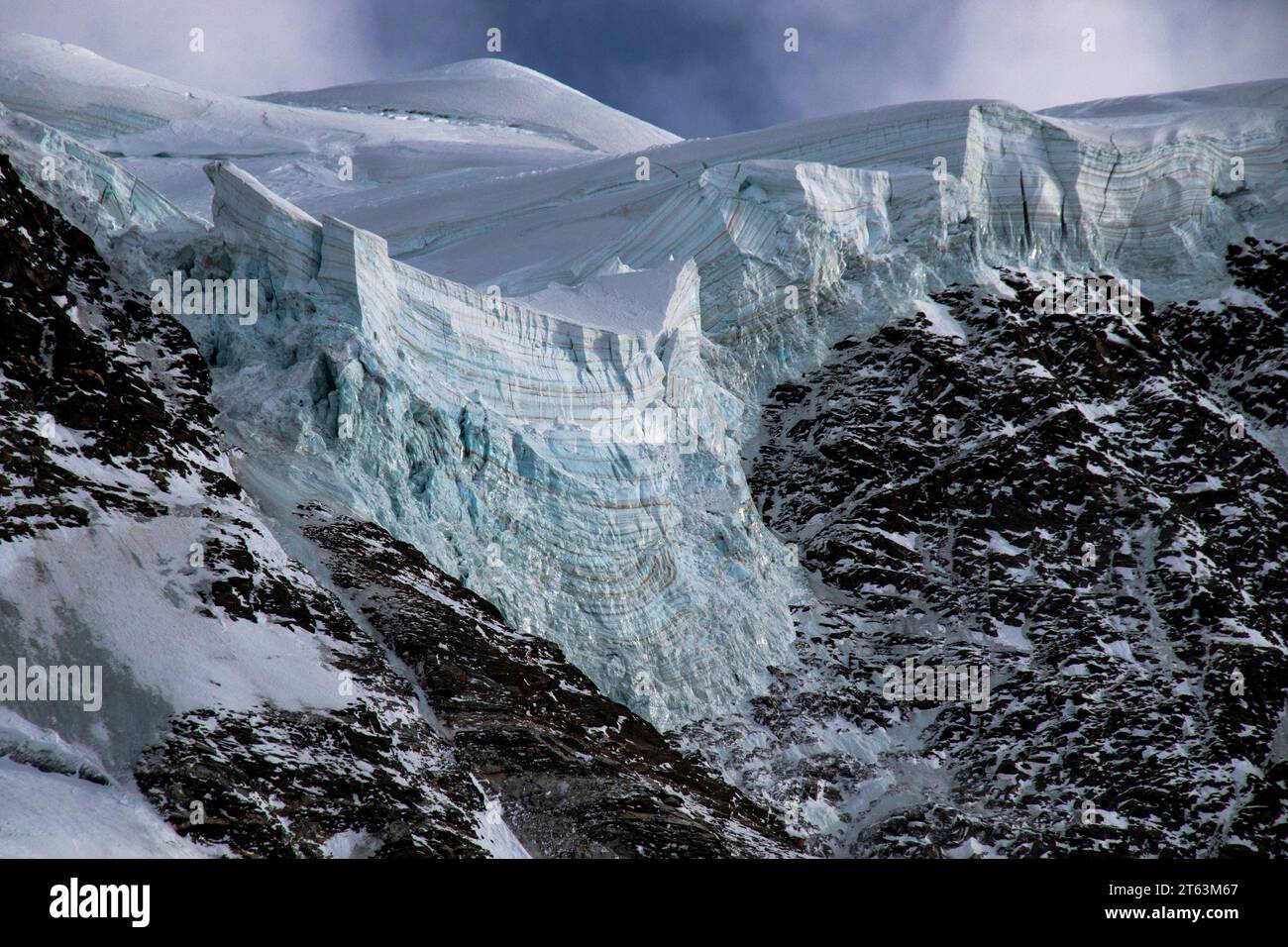 Close up view of a glacier edge with textured ice layers, contrasting ...