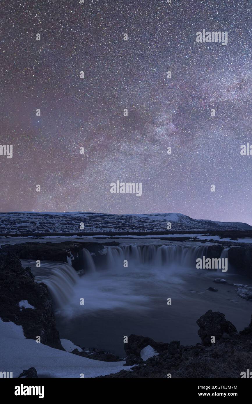 Aerial view of a massive waterfall splitting snowy terrains, with the ...