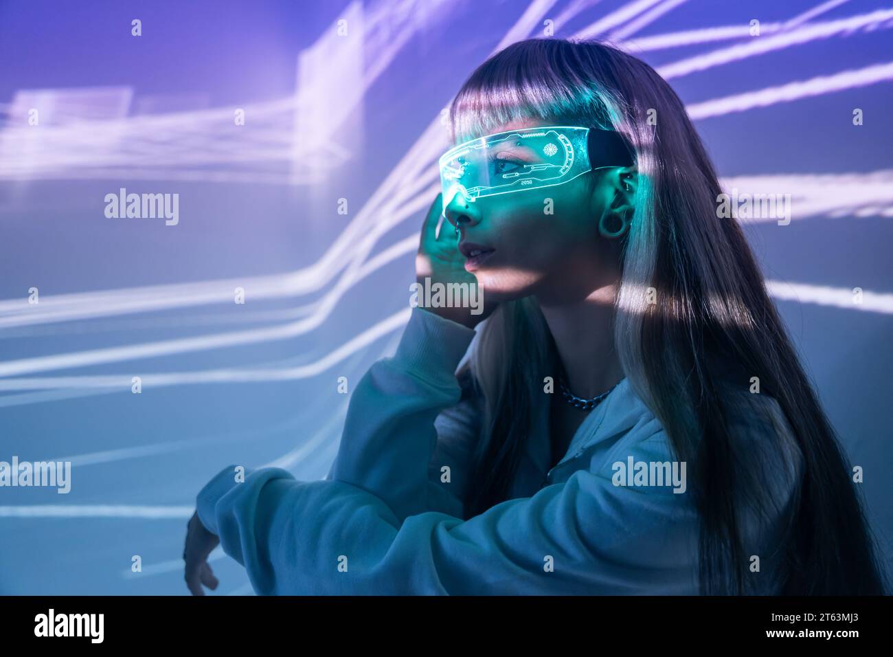 Side view of young woman mesmerized by LED modern VR goggles and ...