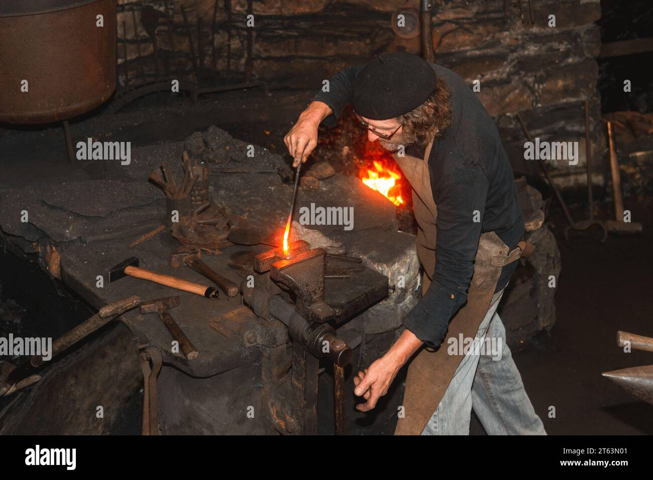 From above of skilled blacksmith clad in traditional wear, meticulously ...