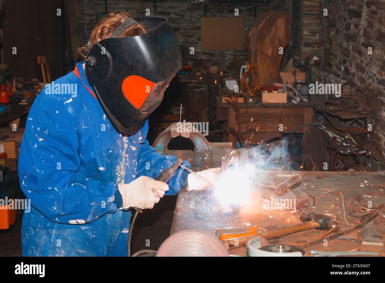 Skilled anonymous artisan sculptor uses welding equipment creating ...