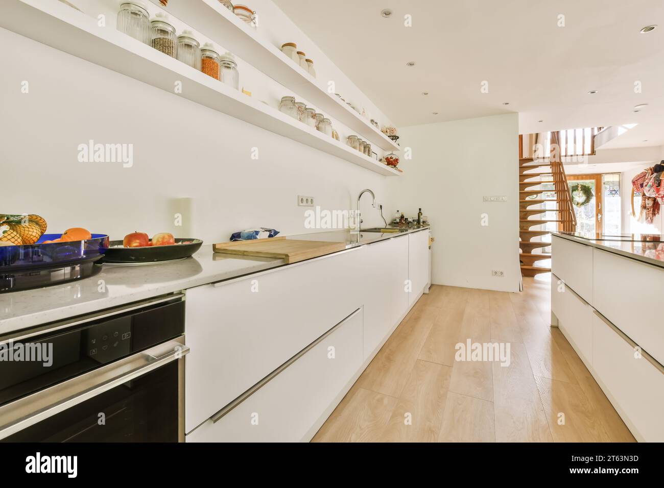 Interior of modern kitchen with white cabinets and long countertop and ...