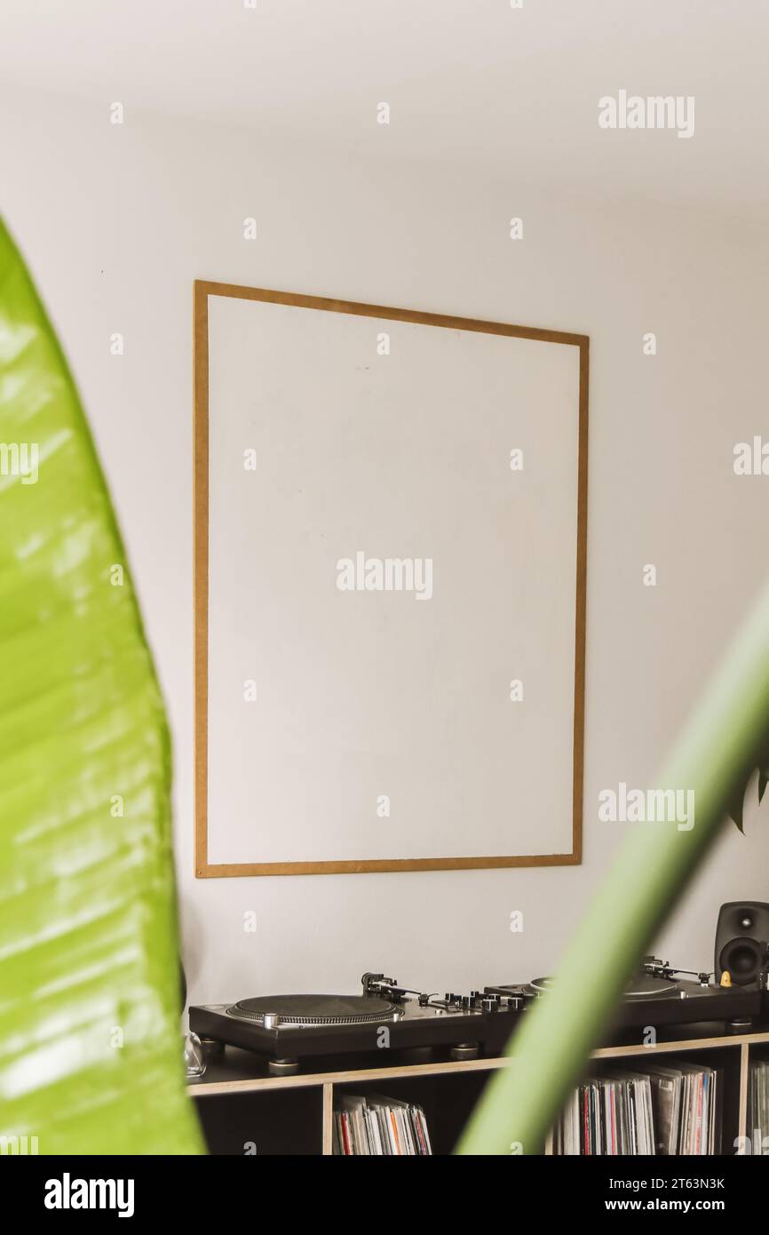 Empty frame mounted on white wall with vintage turntable vinyl record ...