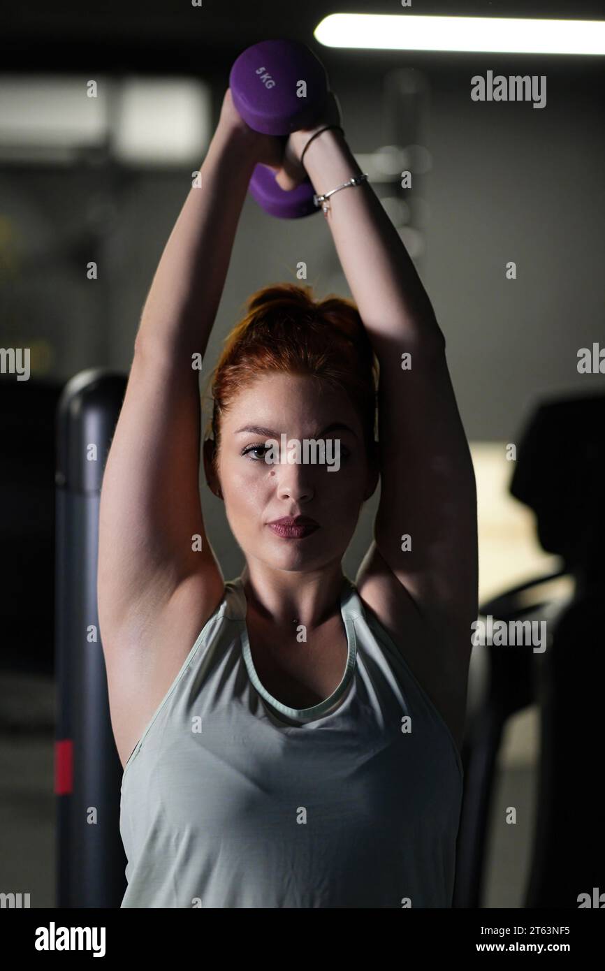 Fitness workout female - Focused woman performing weightlifting ...