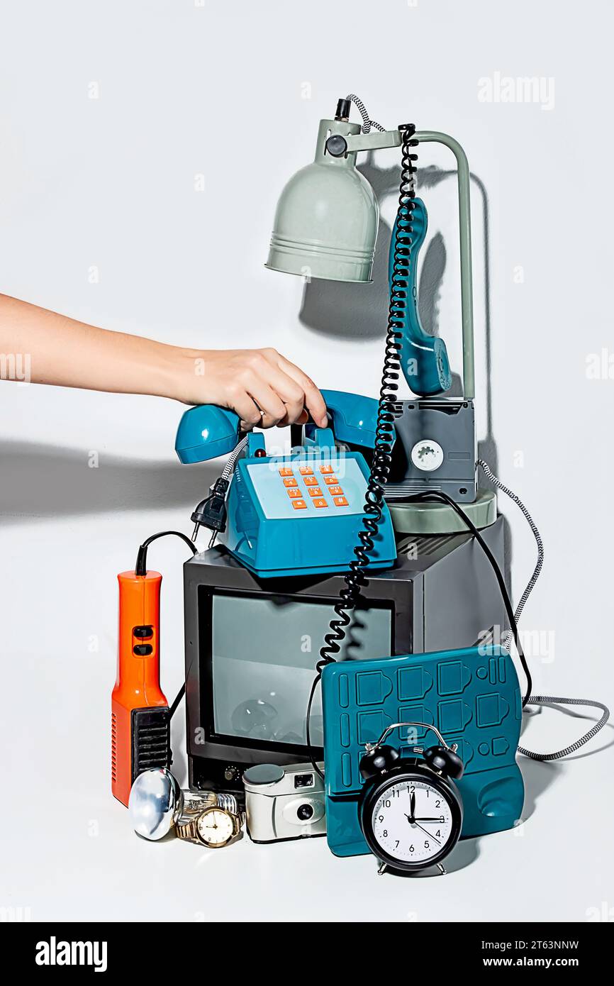 Hand holding a vintage telephone in a curated collection of vintage ...