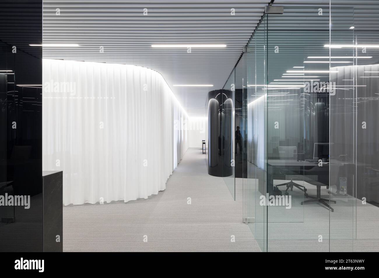 A contemporary office hallway showcasing a unique curved white ...