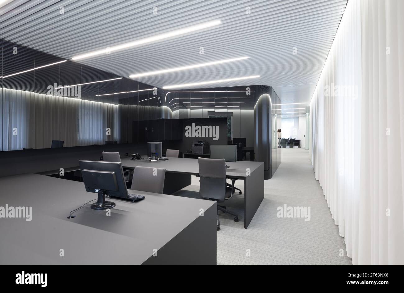 A contemporary office space highlighted by sleek gray workstations ...