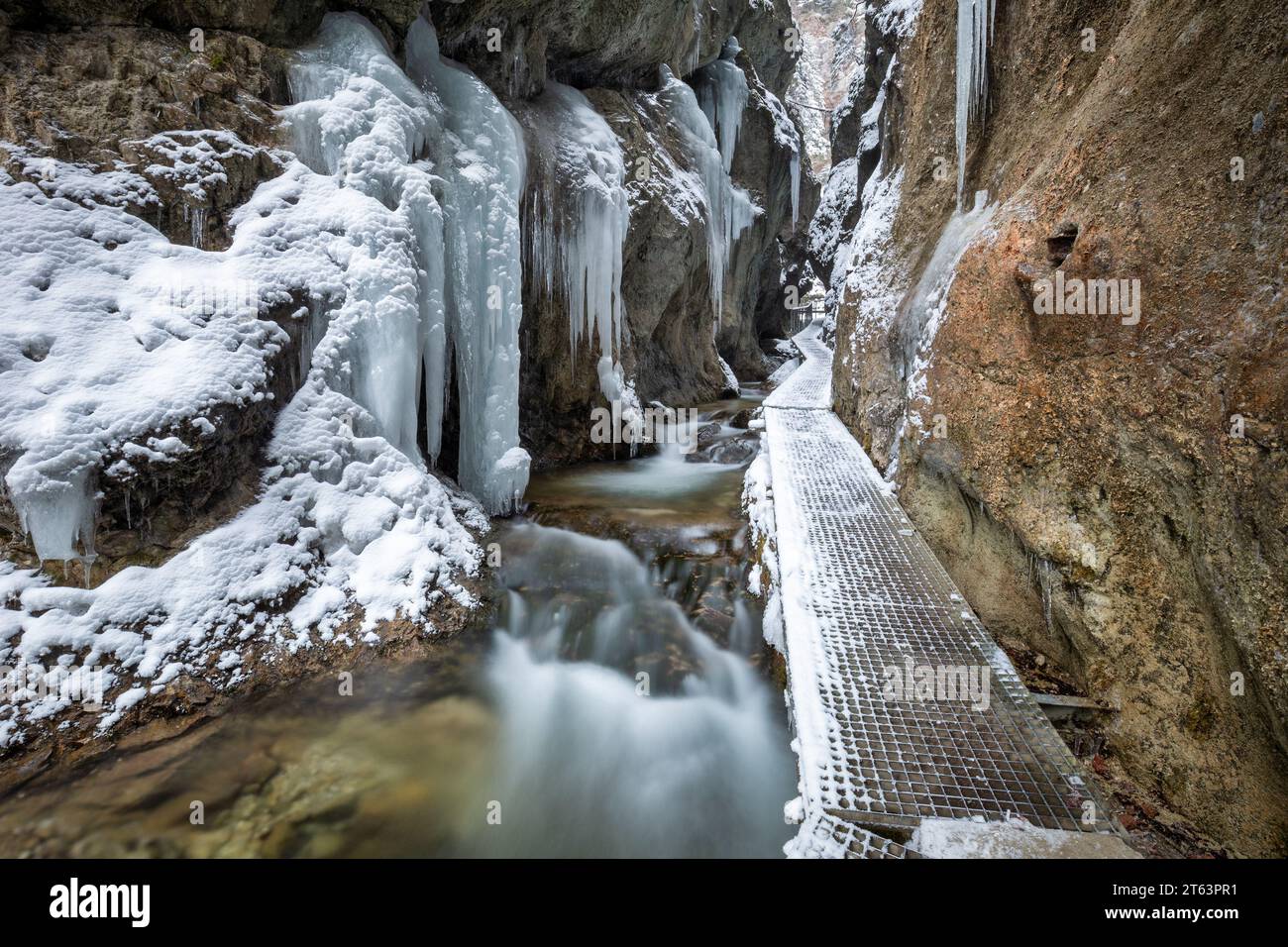 Winter landscape with a wild stream and waterfalls through a narrow ...
