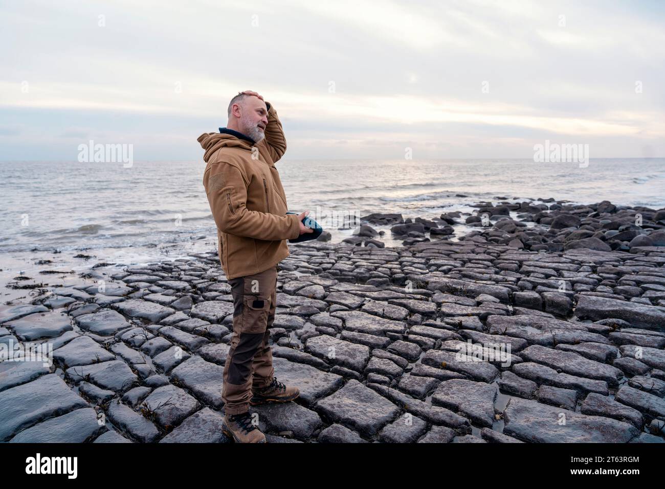 Bearded Man relaxing alone on the seaside on cold winter day. Travel ...