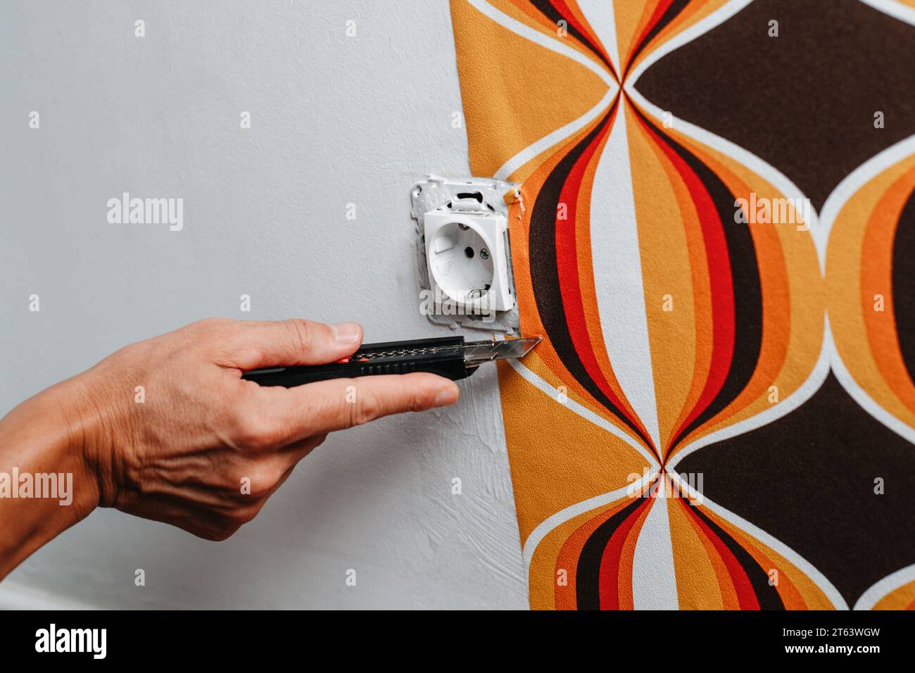 closeup of a caucasian man cutting the edges of a geometric patterned ...