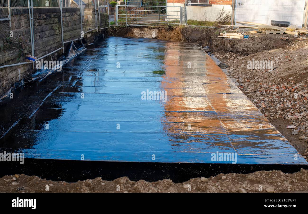 Waterproofing coating. Builder applying waterproofing bitumen mastic on ...