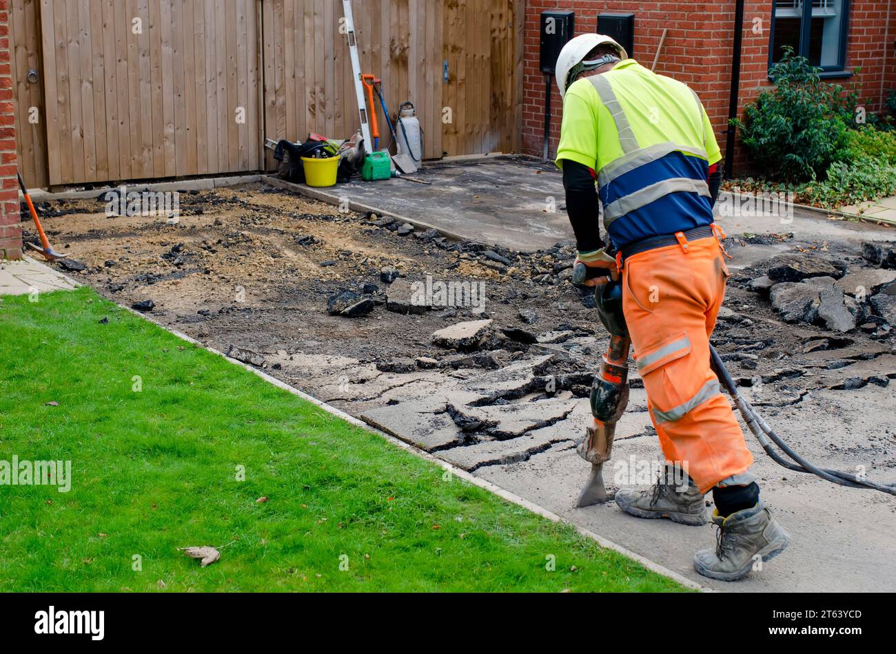 Builder breaking asphalt with hydraulic jackhammer Stock Photo - Alamy