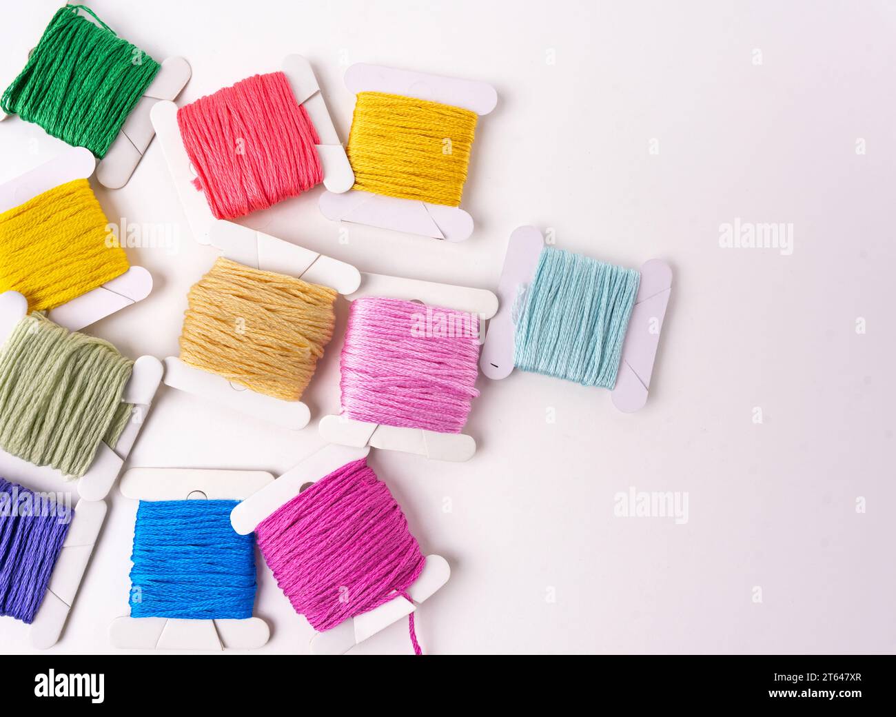 Overhead view of several vibrant colorful thread wound tightly on ...