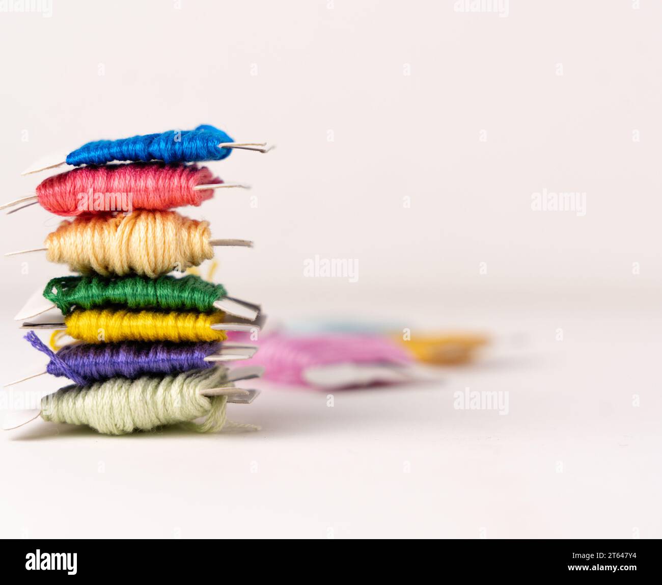 Stacked vertical view of several vibrant colorful thread wound tightly ...