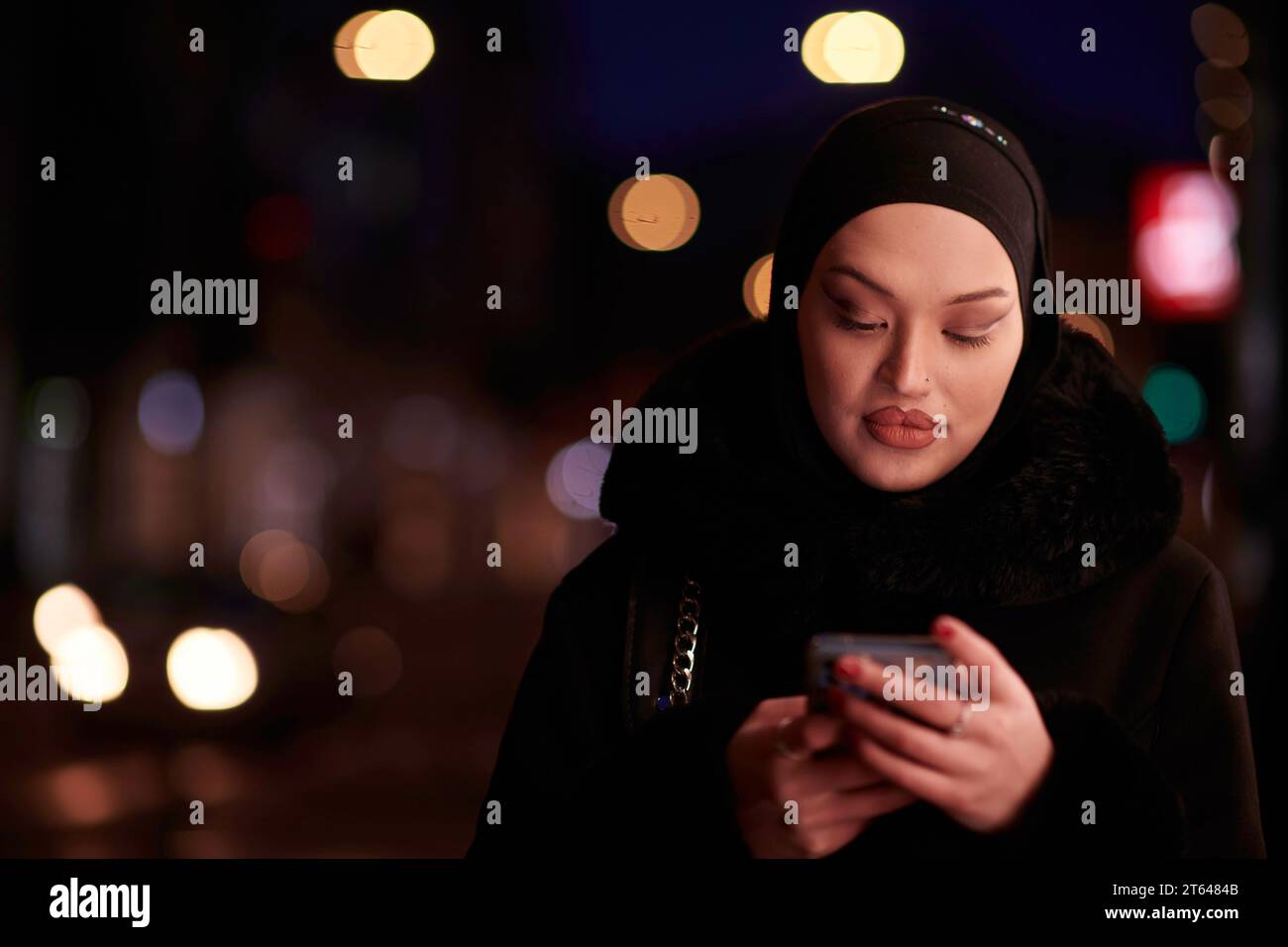 uropean Muslim Hijabi Business Lady checking her phone on urban city ...