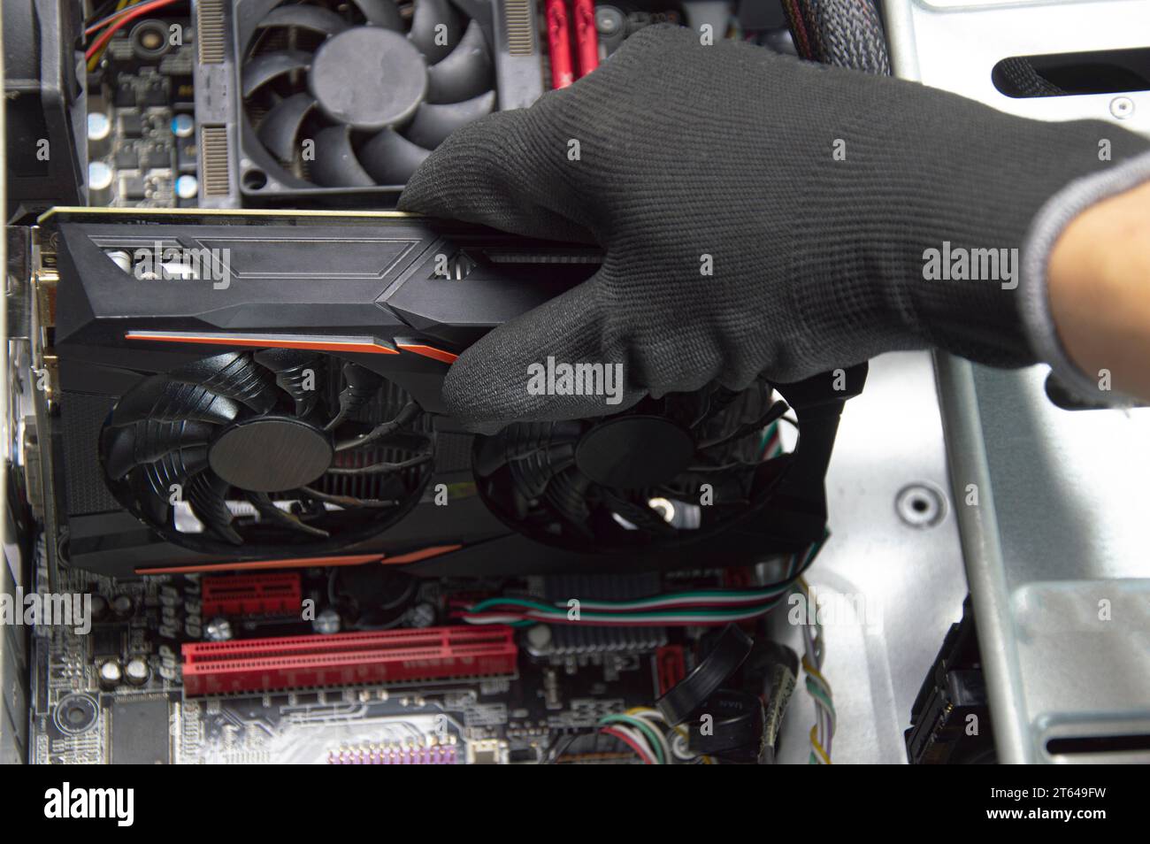 Top view of graphics card being assembled by technician on motherboard ...