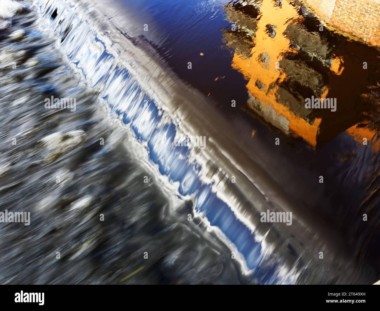 Abstract patterns and reflected modern buildings in the River Aire at ...