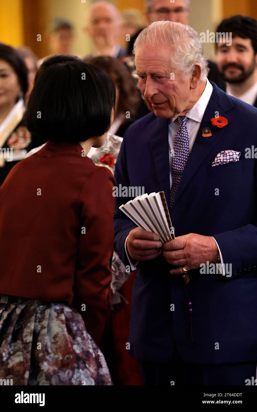 King Charles III is handed a fan during his visit to New Malden ...
