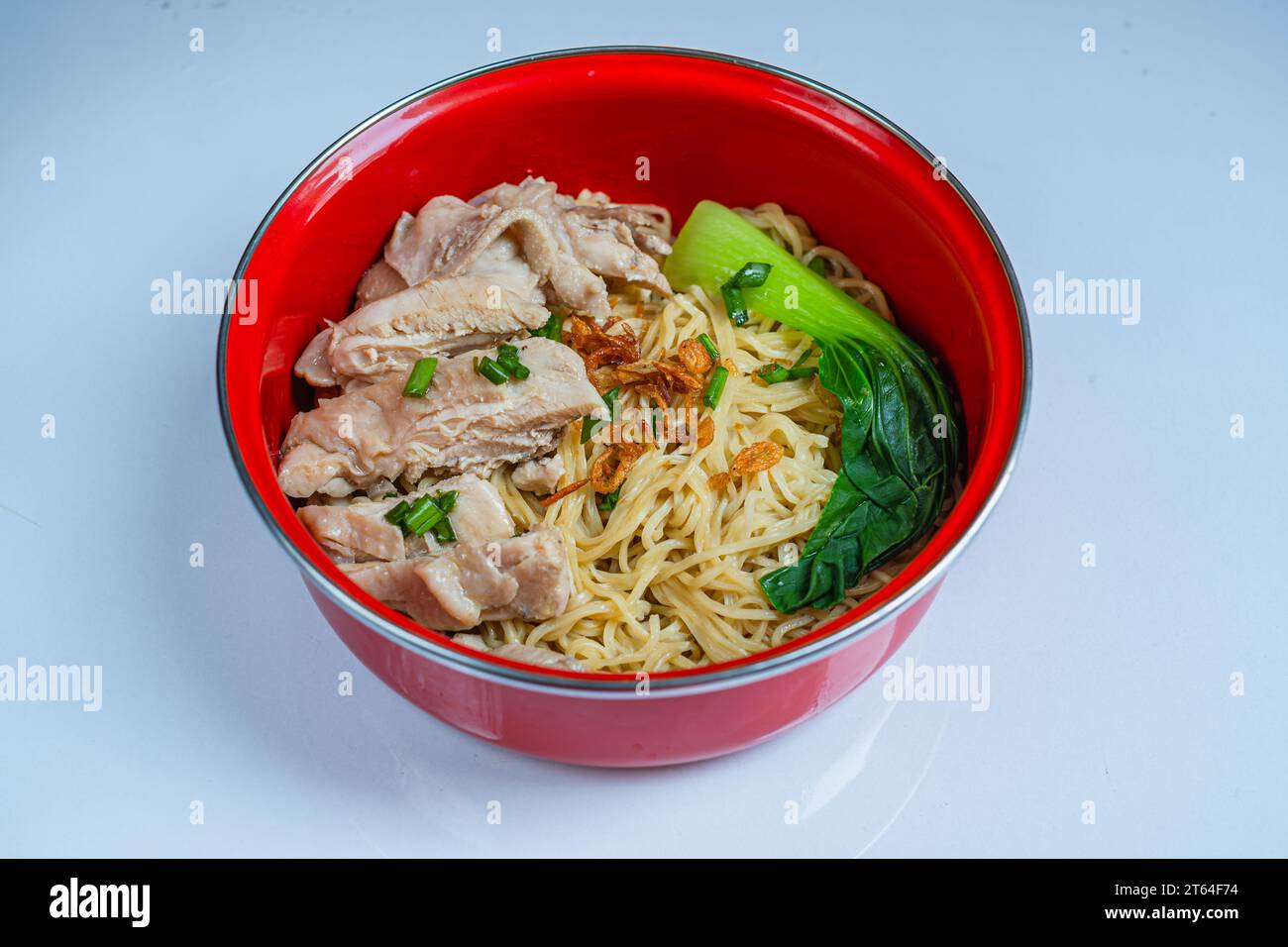 Mie Hainan or Hainan noodles with steamed chicken in a red bowl ...