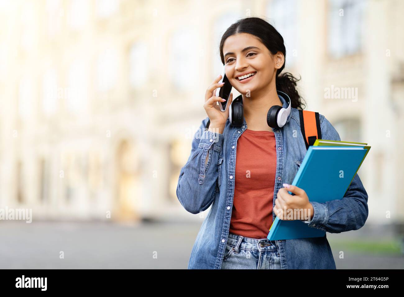 Happy pretty young indian woman student talking on phone outdoor Stock ...