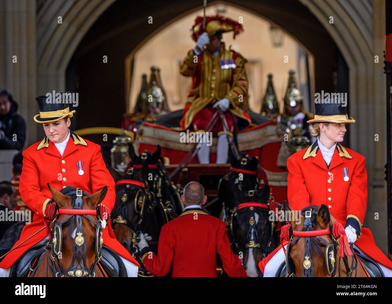 Mounted female Outriders in scarlet livery precede the carriage ...