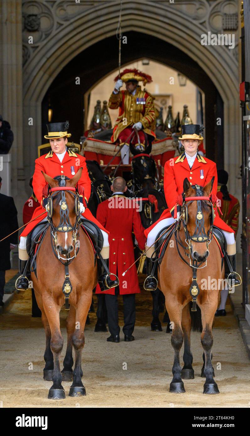Mounted female Outriders in scarlet livery precede the carriage ...
