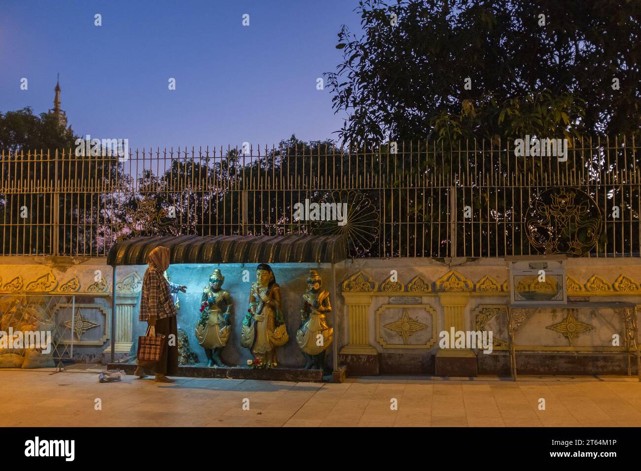 Yangon, Myanmar. At the Shwedagon Pagoda before daybreak, a worshipper ...