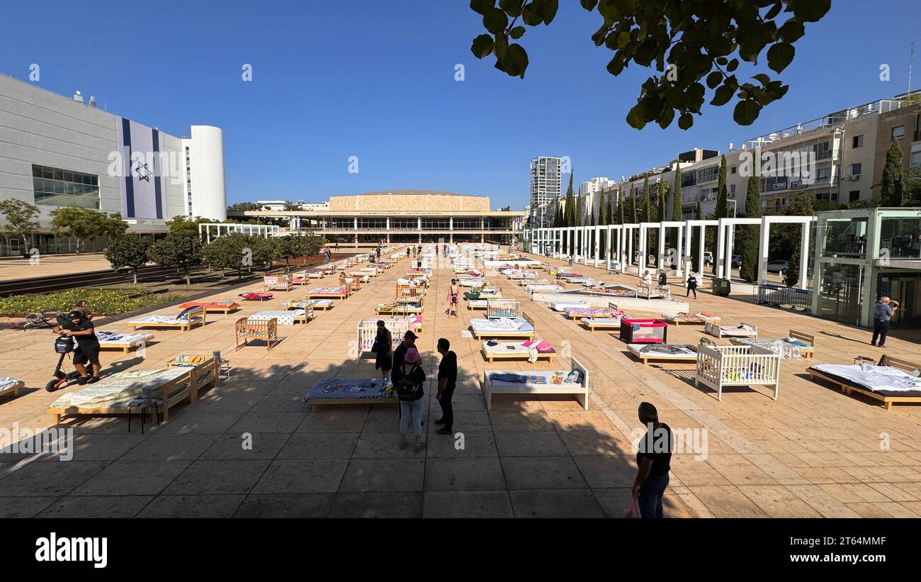 An art installation of "empty beds" and a "hostage table" in front of ...