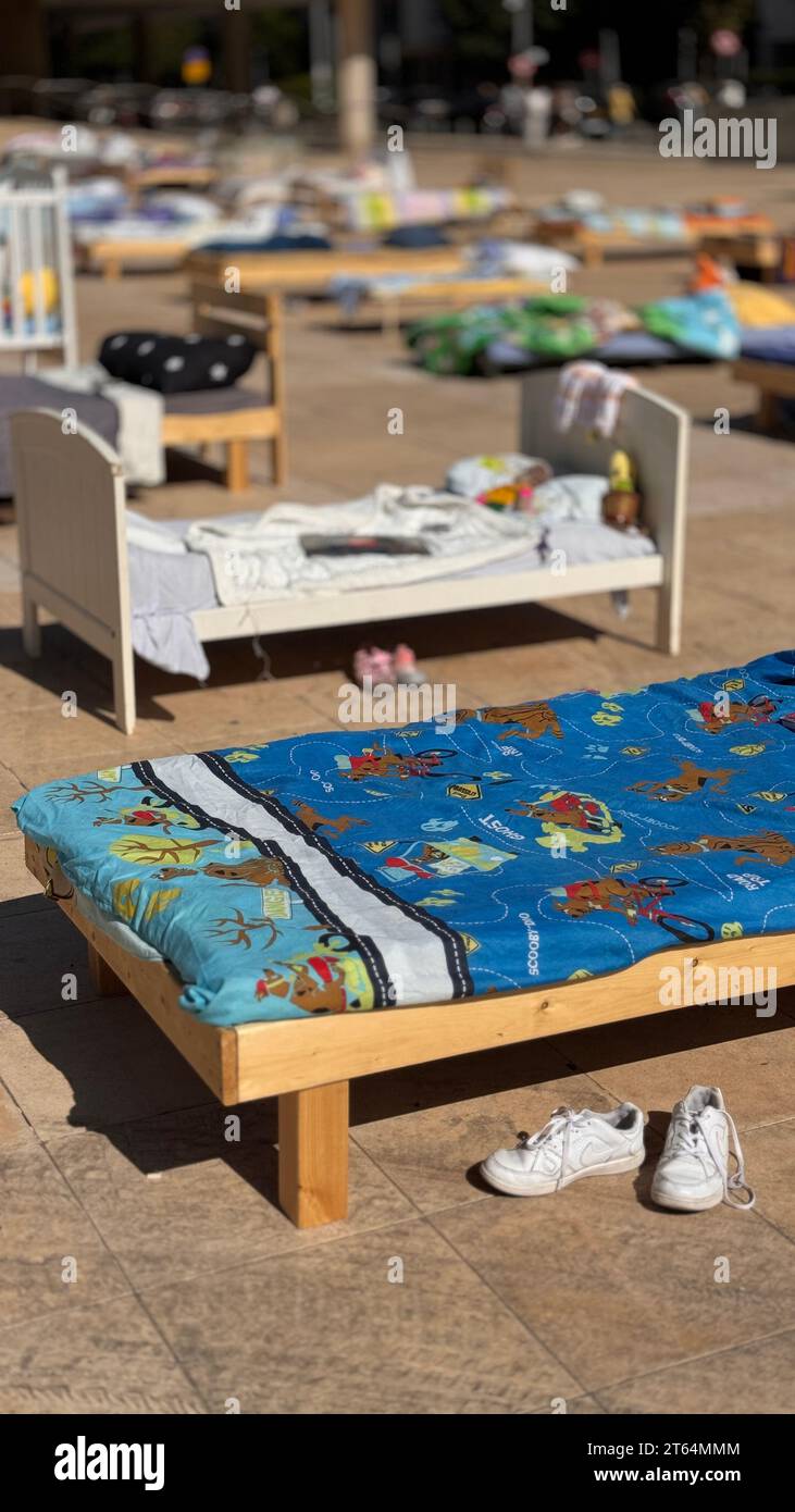 An art installation of "empty beds" and a "hostage table" in front of ...