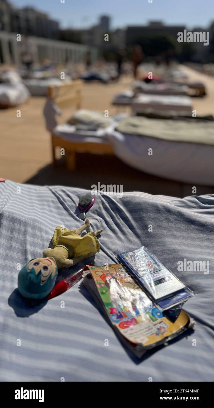 An art installation of "empty beds" and a "hostage table" in front of ...