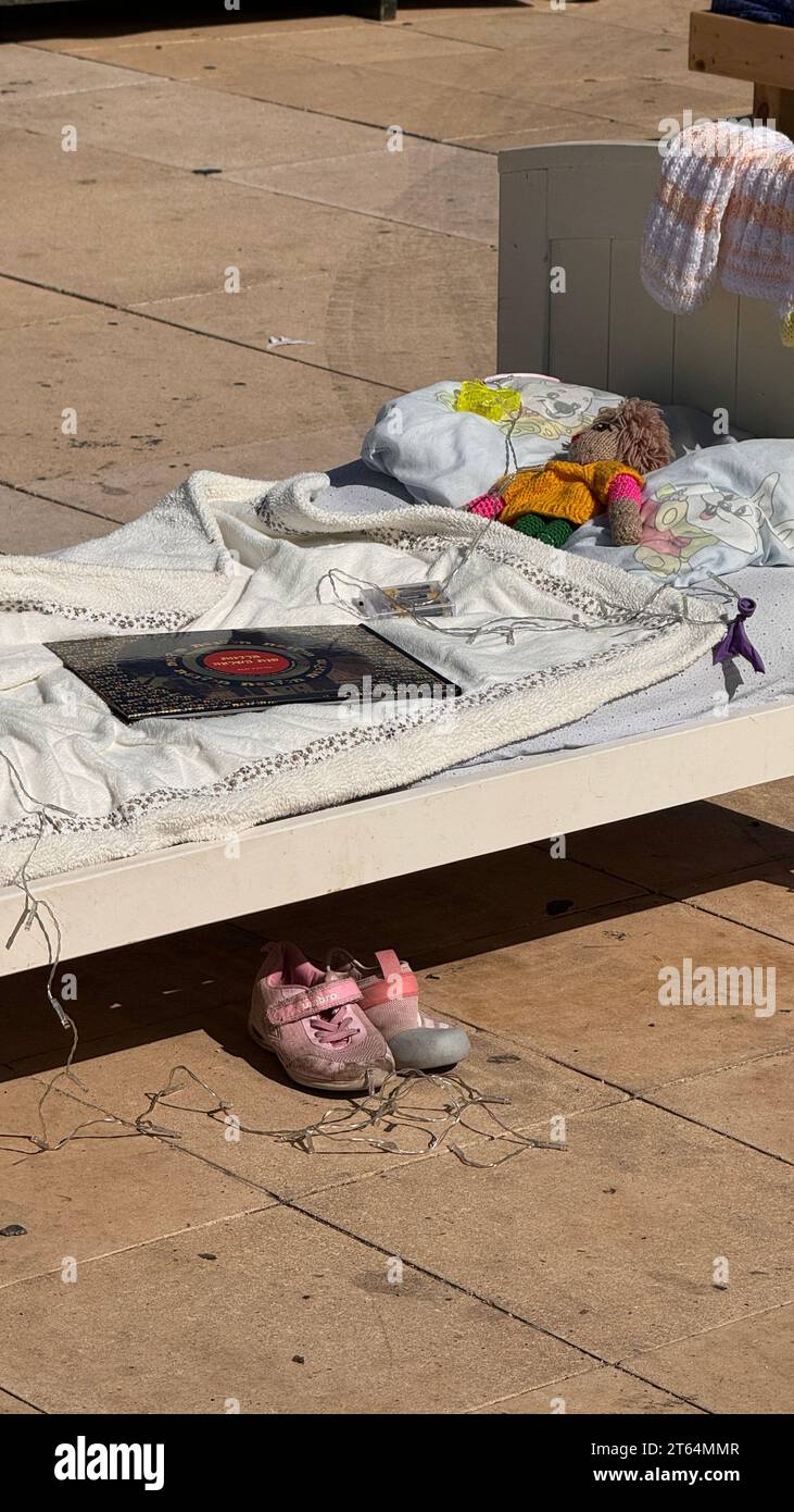 An art installation of "empty beds" and a "hostage table" in front of ...