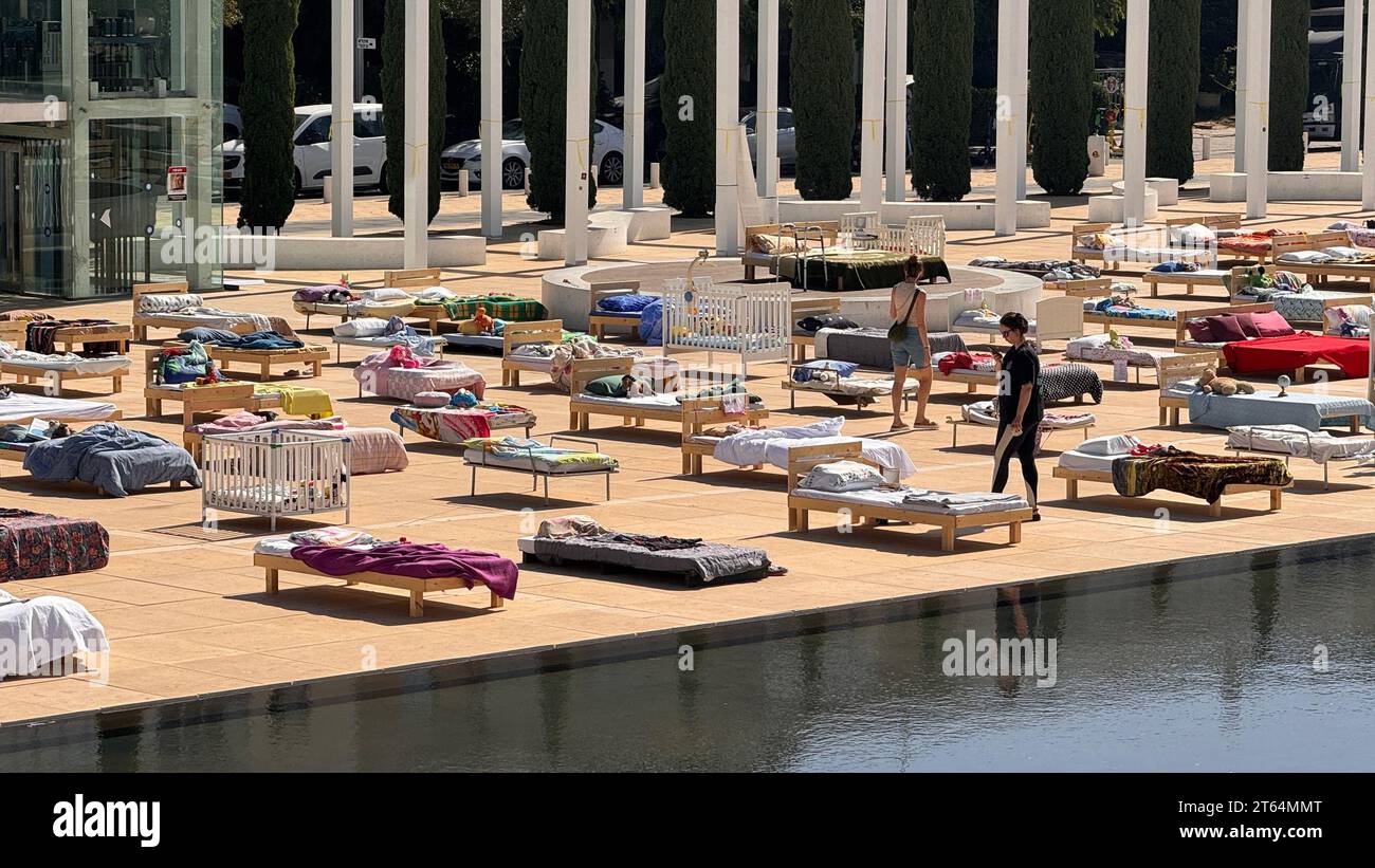 An art installation of "empty beds" and a "hostage table" in front of ...