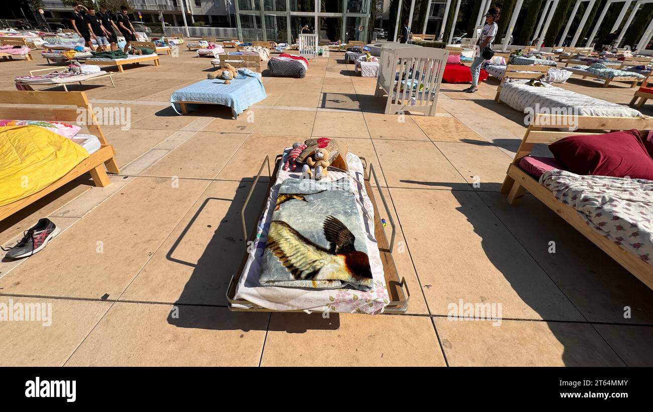 An art installation of "empty beds" and a "hostage table" in front of ...