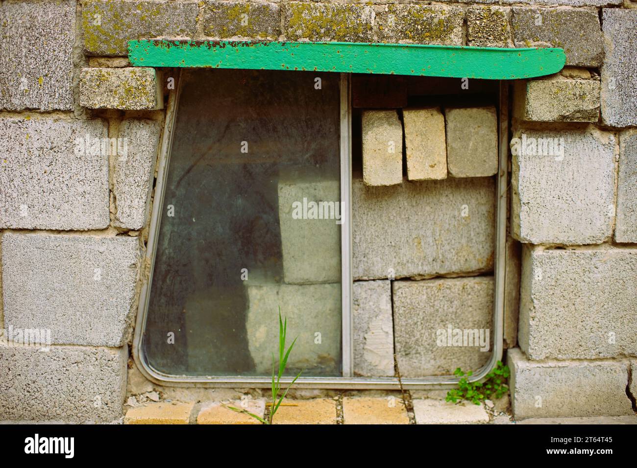 Old homemade design with bus window on the fa?ade wall of cinder block ...