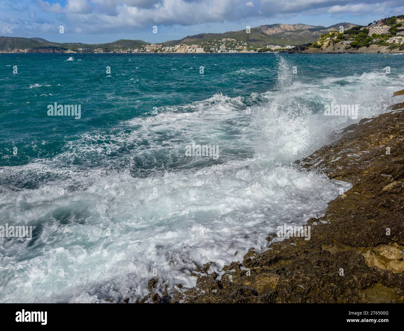 Surf, spray, waves breaking on the rocky coast, behind Peguera, Majorca ...