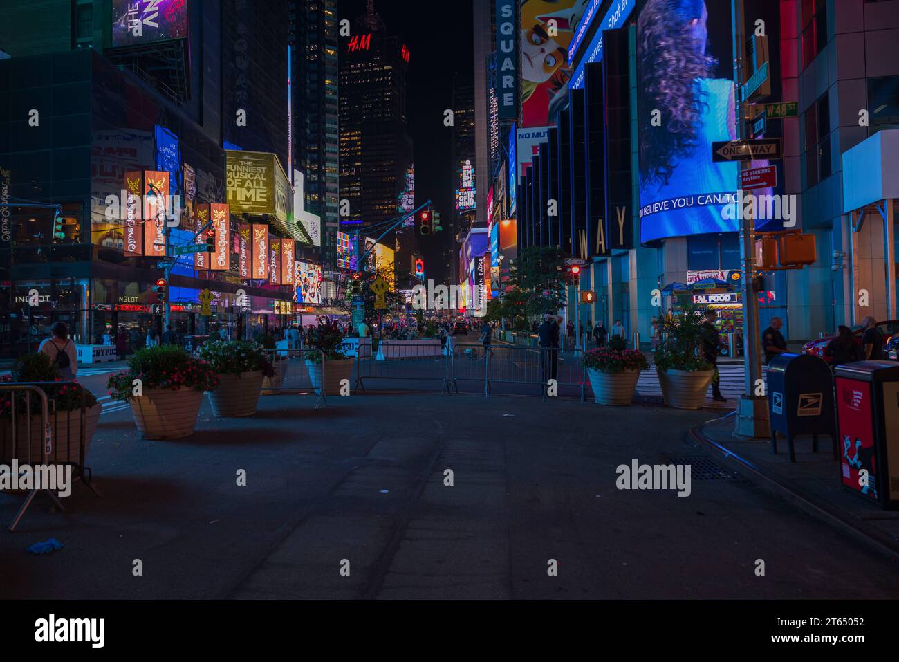 Nighttime Times Square in Manhattan with people strolling amid ...