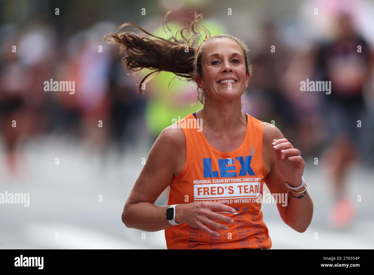 Runner Alexis Herron of New York City looks very happy as she passes ...
