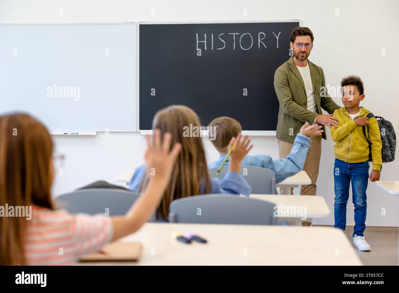 Teacher introducing a new boy to the classmates Stock Photo - Alamy