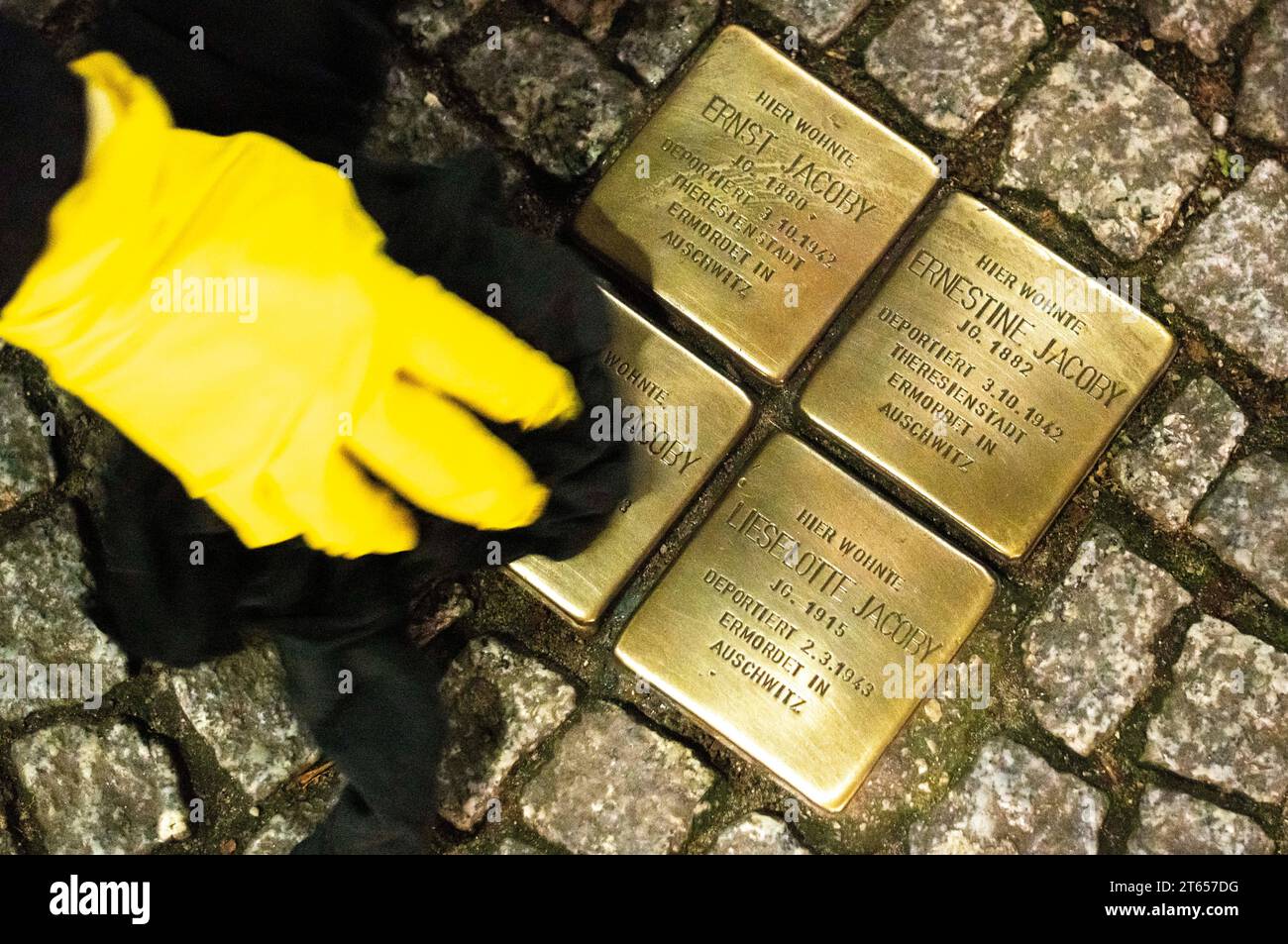 A man polishes so-called 'Stolpersteine' or 'stumbling stones ...